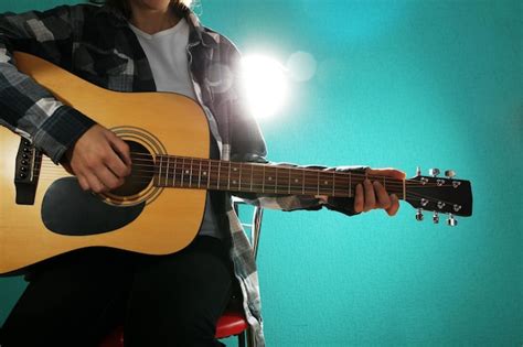 Premium Photo Musician Plays Guitar On Blue Background Close Up