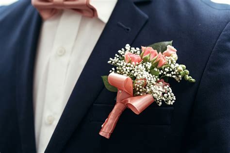 분홍색 장미 Boutonniere와 나비 넥타이 포즈와 정장에 세련된 신랑 또는 신랑 결혼식을위한 아침에 준비 개념에 대한 스톡
