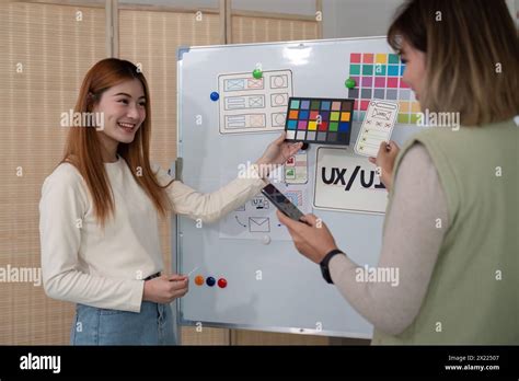 Ux Developer And Ui Designer Presenting Mobile App Interface Design On Whiteboard In Meeting At