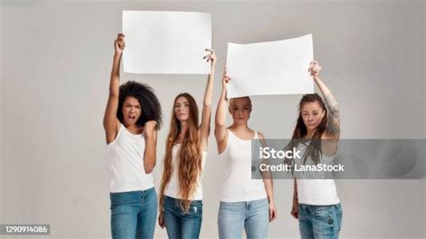 네 명의 다양한 여성들이 카메라를 들고 서서 회색 배경 위에 고립된 빈 현수막을 들고 서 있었다 페미니즘과 평등 개념 169에 대한 스톡 사진 및 기타 이미지 Istock
