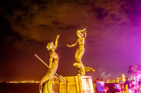 Mermaid And Merman Sculpture Of Love In Night With Lights Of Colors