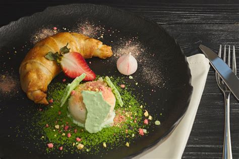 머 랭과 딸기로 장식 된 나무 블랙 테이블에 검은 접시에 바닐라 아이스크림의 특 종을 가진 사과 슈트 루 델 슬라이스 클로즈업 구운 디저트의 수평 보기 0명에 대한 스톡