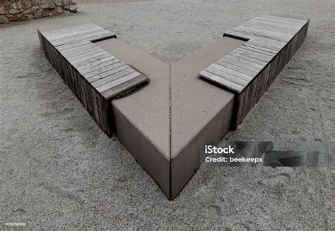 V 자형 콘크리트 한 조각으로 만든 벤치 화살표 모양의 공원 벤치가 두 개로 나눌 수있는 거울 모양의 물체입니다 공원의 자갈