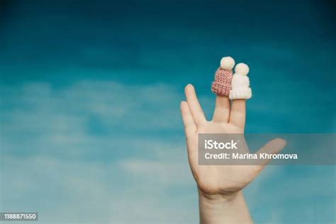 파란색 배경에 여성 손바닥 두 손가락 니트 모자를 입고 벌컨의 인사말 개념에 대한 스톡 사진 및 기타 이미지 개념 개념과 주제 겨울 Istock