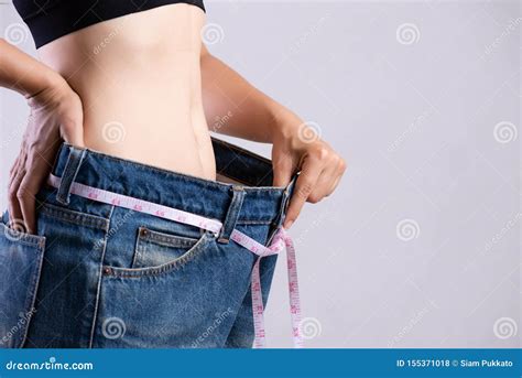 Fin Vers Le Haut De La Jeune Femme Mince Mesurant Sa Taille Mince Avec