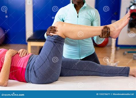 Physiotherapist Giving Leg Massage To Active Senior Woman In Sports Center Stock Image Image