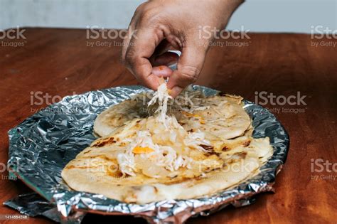 알루미늄 호일에 샐러드를 곁들인 니카라과 번데기 나무 테이블에서 제공되는 맛있는 살바도란 번데기의 전망 테이블에 샐러드와 함께