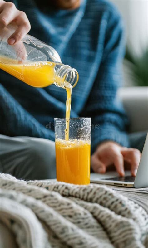 Person Pouring Fresh Orange Juice From Jug To Drinking Glass Stock