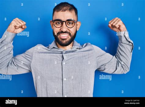 Middle East Man With Beard Standing Over Blue Background Showing Arms