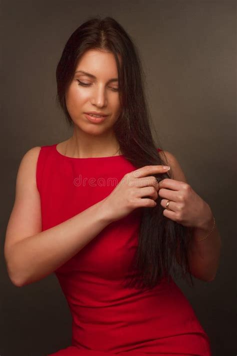 Portrait Of A Brunette On A Gray Studio Background In A Red Dress Stock