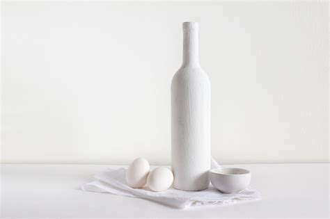 밝은 배경에 있는 흰색 와인 병은 소금 셰이커와 달걀을 수건에 달걀로 세워줍니다 0명에 대한 스톡 사진 및 기타 이미지 0명