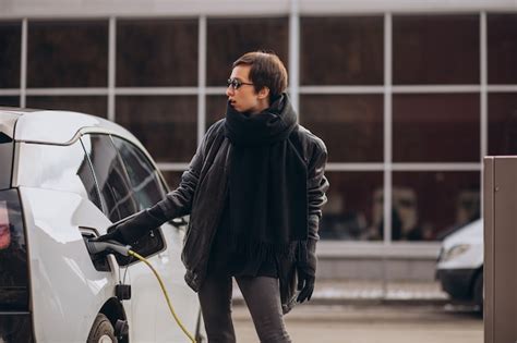 Free Photo Woman Charging Electro Car At The Street