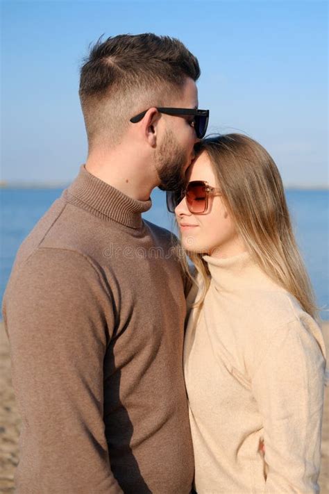 Bella Pareja Joven Posando Contra El Cielo Azul Y El Agua El Tipo