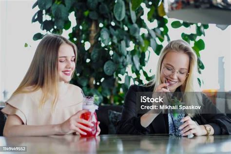 Zwei Junge Schöne Mädchen Blondine Und Brünette Sitzen An Einem Tisch