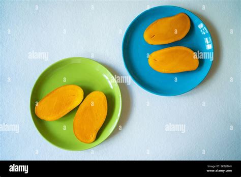 A Top View Of The Tasty Ripe Mango Slices On The Blue And Green Plates
