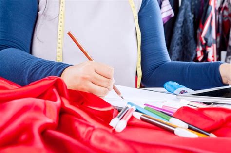 Premium Photo Unknown Female Tailor Drawing A Design On Paper
