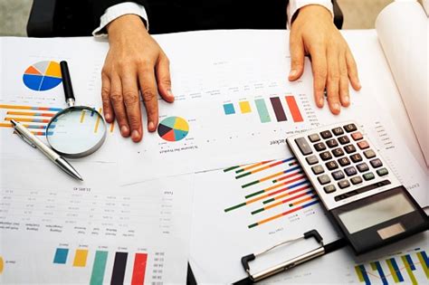 현대 사무실 재무 및 비즈니스 개념에서 차트 그래프 및 계산기로 재무 보고서 프로젝트 회계를 작업하고 분석하는 아시아 회계사