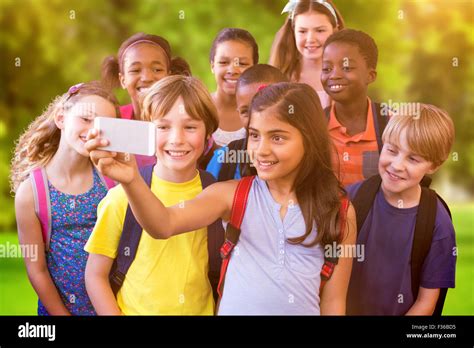 Composite Image Of Cute Pupils Using Mobile Phone Stock Photo Alamy