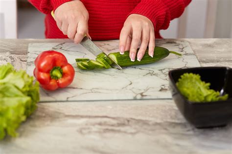여 대 손 컷 야채 칼 조각 오이 고추와 부엌 식탁에 상 추의 자른된 이미지 준비 Vegeterian 신선한 샐러드 빨간 옷을