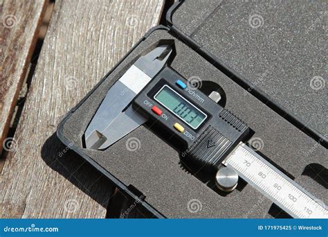High Angle Shot Of A Digital Caliper In A Box On A Wooden Surface Stock