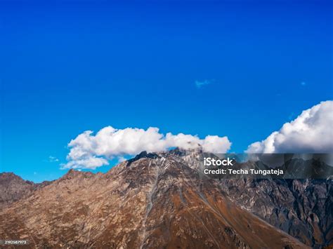 눈 갈색과 검은 색 바위 언덕 흰 구름과 푸른 하늘 배경으로 덮인 높은 산 봉우리 조지아 국가에서보기 아름 다운 산과 풍경 풍경 배경입니다 0명에 대한 스톡 사진 및 기타