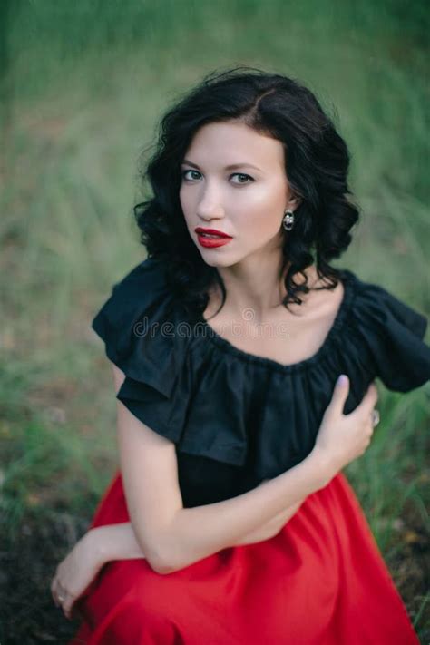 Young Brunette Model In Red Skirt Black Jacket And Red Lips Stock