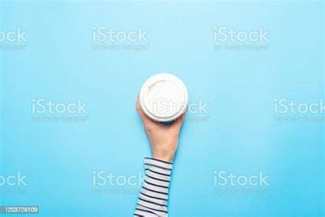 여성의 손은 파란색 배경에 커피와 종이 컵을 들고있다 커피의 개념 따뜻한 음료 아침 식사 배너 플랫 레이 상단 보기 공란에 대한
