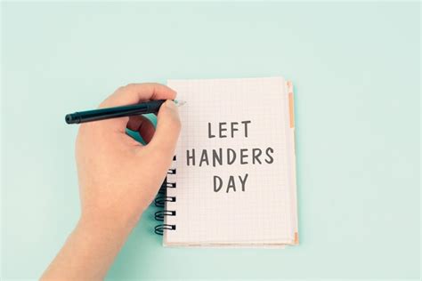 Premium Photo Left Handers Day Is Standing On A Notebook Writing With
