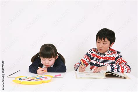 색칠 공부하는 여자아이와 공부하는 남자아이 스톡 사진 Adobe Stock