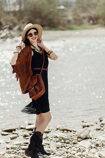세련 된 Boho 여행자 여자 모자 프린지 판 쵸 집시 Hipster 여자 근처에 물 강 해변 산 포즈 방 랑 벽 여름