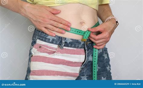 A Girl Is Measuring Her Waist With A Centimeter Tape The Woman Is