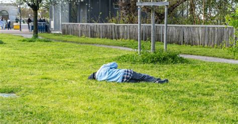 Homeless Man Sleeping On City Lawn In Bordeaux Homeless In France