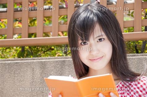 本を持って微笑む女性の写真素材 24021487 イメージマート