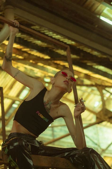 90 년대 스타일 가죽 바지 건축 구조 그래피티 그런지 극적인 포즈 금속 빔 단색 의상 담배 담배를 피우는 대담한 대머리 대체 패션 도시 설정