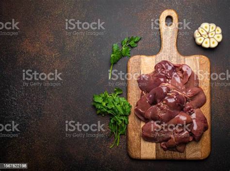 나무 도마에 있는 생 닭 간은 어둡고 소박한 콘크리트 배경 식탁에 앉아 있다 건강 식품 성분 철분 엽산 비타민 미네랄의 공급원 텍스트를 위한 공간 0명에 대한 스톡 사진 및