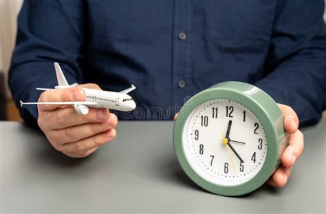 A Man Holds A Passenger Plane And A Clock Flight Time Stock Image A Man Holds A Passenger Plane And A Clock Flight Time Stock Image