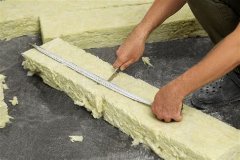 Worker Measuring And Cutting Insulation Material Indoors Closeup Stock