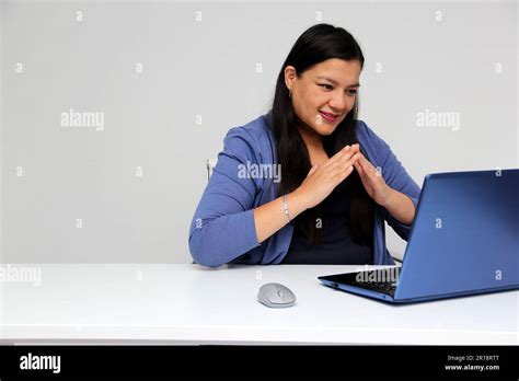 Latino Adult Woman Speaks Mexican Sign Language With A Deaf Person Through A Laptop In A Video