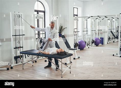Woman Doing The Knee Flexion Assisted By A Rehabilitation Physician