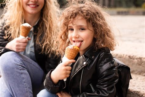 Die Glückliche Mutter Und Tochter Halten Eis Beim Gehen Premium Foto