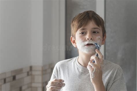 Schoolboy With Shaving Foam On Face Imitates Shaving Beard Like His