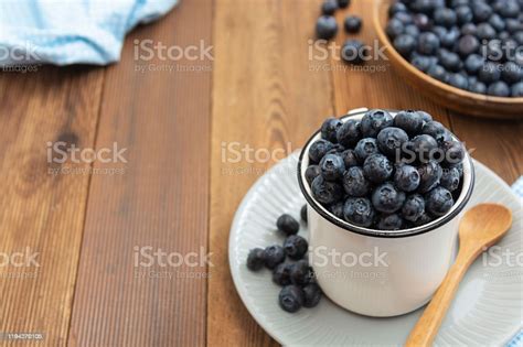 나무 테이블에 금속 컵에 잘 익은 블루 베리 아침 식사로 신선한 열매 공간을 복사합니다 건강한 생활방식에 대한 스톡 사진 및