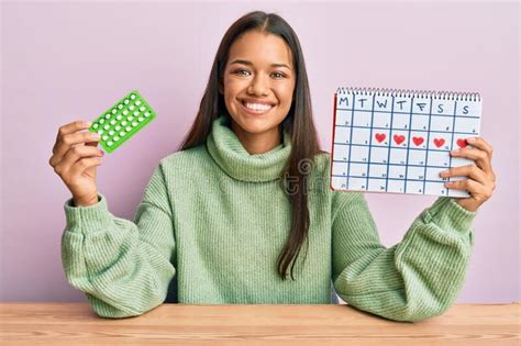 Beautiful Hispanic Woman Holding Birth Control Pills Smiling With A