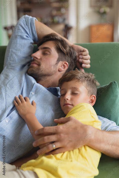 Father And Son Sleeping Together On A Sofa In Living Room Stock Photo Adobe Stock