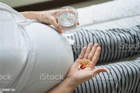 임신한 여자 반면에 물의 유리를 가진 그녀의 손에 알 약과 태블릿을 수행 임신에 대한 스톡 사진 및 기타 이미지 임신 철