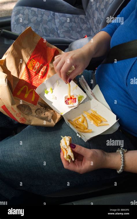 A Woman Eating A Mcdonalds Fast Food Inside A Car With A Chicken