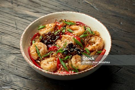 맛있는 아시아 길거리 음식 나무 배경에 흰색 그릇에 새우 실란트로 야채와 오믈렛과 Funchoice 국수 Tcellophane