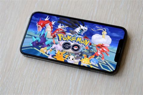 Pokemon Go Mobile Ios Game On Iphone 15 Smartphone Screen On Wooden