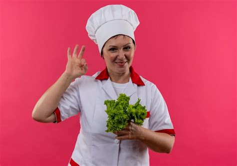 Free Photo Smiling Middle Aged Female Cook In Chef Uniform Holding