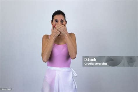 충격당한 무서운 발레 댄서 양손으로 입을 가리는 중년 여성 모델의 초상화 회색 배경 스튜디오 샷 발레 저지 D에 고립 된 카메라